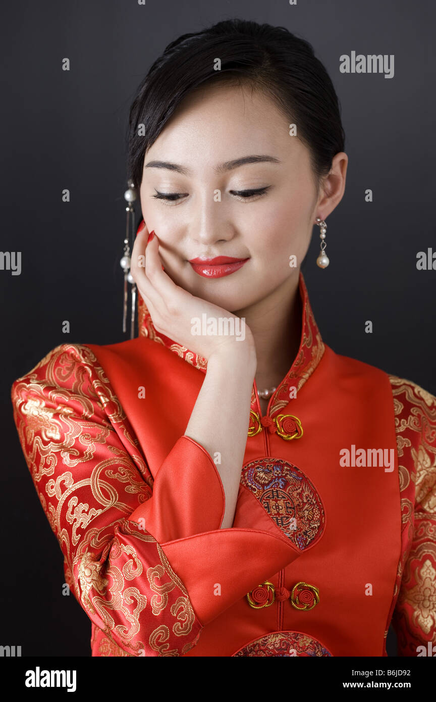Young woman in cheongsam putting her hand on chin Stock Photo - Alamy