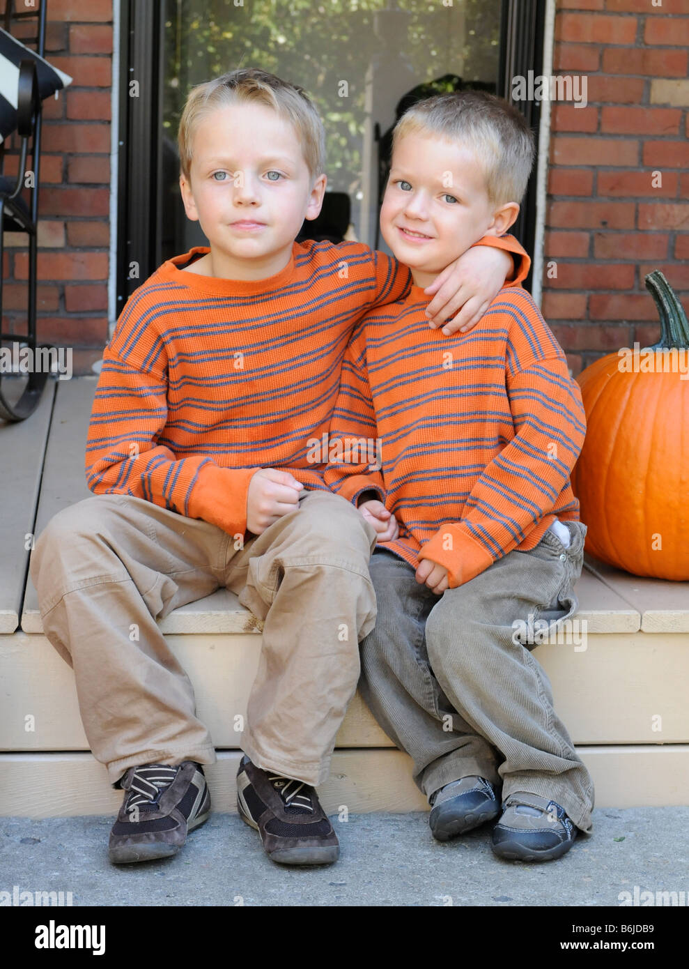 Brothers in arms sitting on the stoop Stock Photo - Alamy