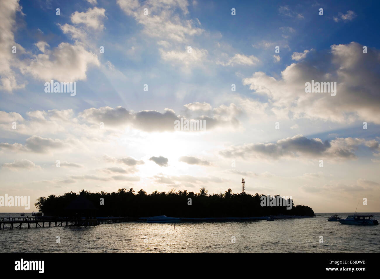 Sun setting behind a tropical island in The Maldives Stock Photo - Alamy