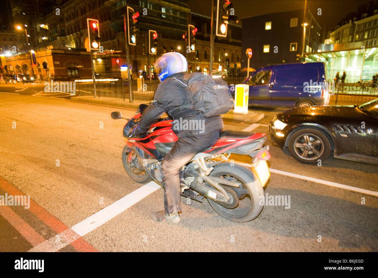 A motorcyclist at night outside Kings Cross London UK Stock Photo - Alamy