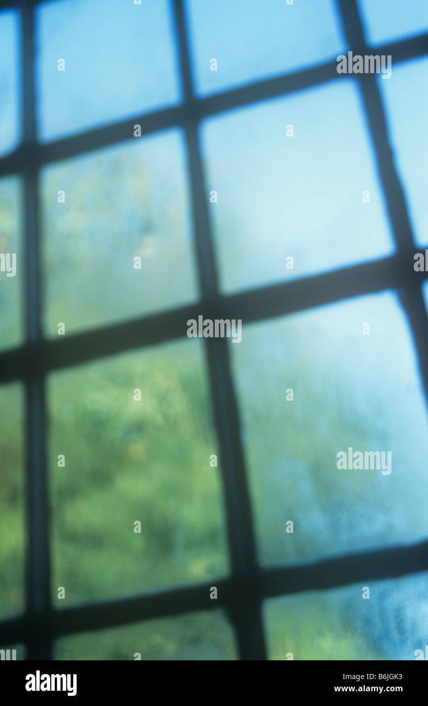 Impressionistic view through part of classical square-paned window with ...