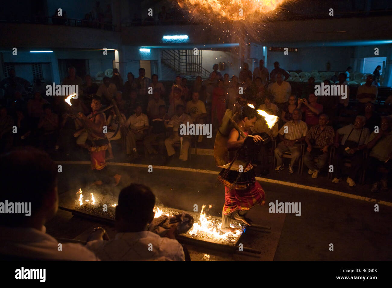 Performers walking across fire in front of an audience in Kandy, Sri ...