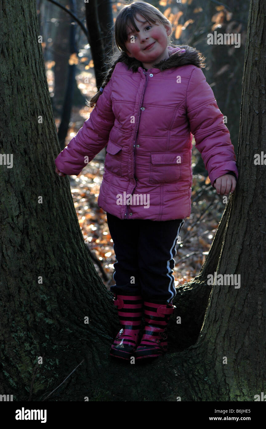 A young girl standing on a tree Stock Photo - Alamy