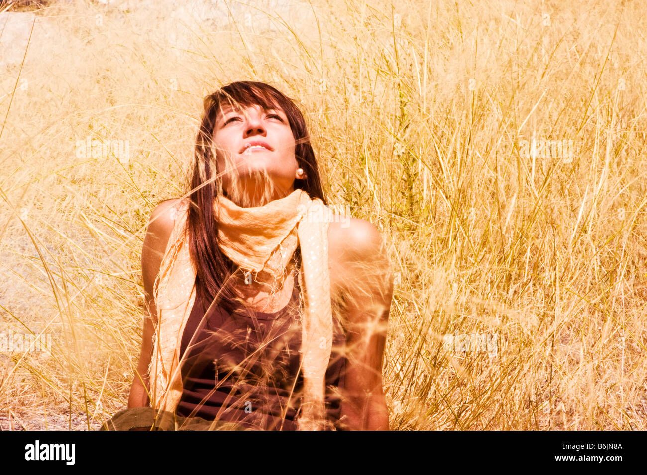 Young woman staring at the sun in the middle of a field Stock Photo - Alamy