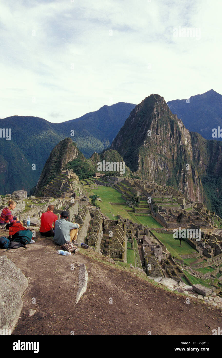 South America, Peru, Machu Picchu. Tourists viewing the stone walls and ...