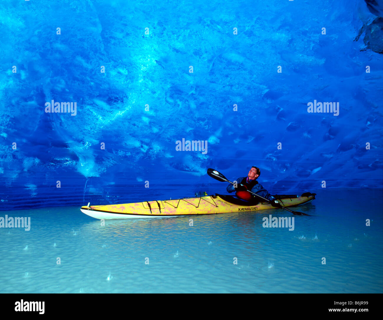 Sea kayaker Ehren in ancient ice cave, Russell Fjord Wilderness, near ...
