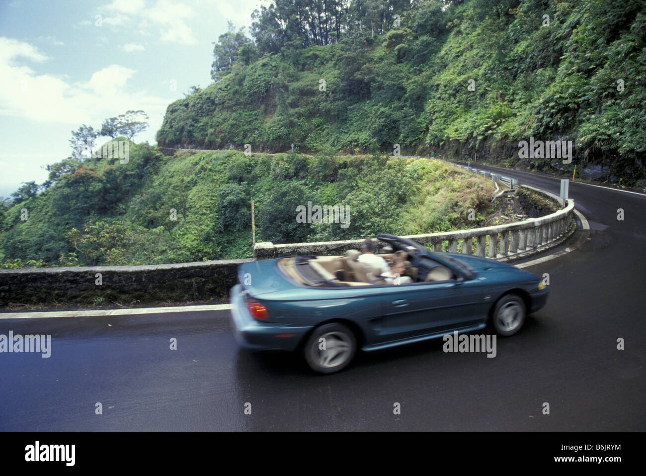 N.A., USA, Hawaii, Maui, Green convertible navigates one of many turns ...
