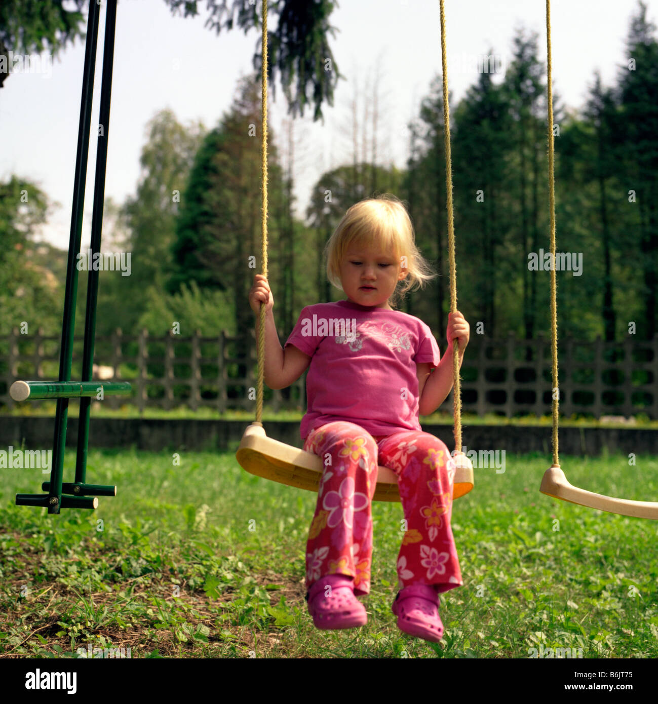 Toddler girl on rocker in the garden Stock Photo - Alamy