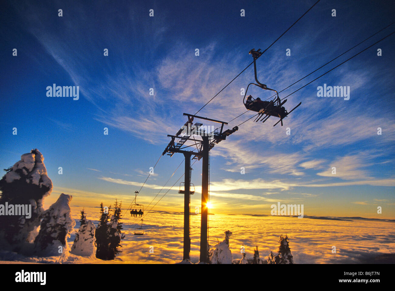 Skiers on Chairlift above inversion clouds at Big Mountain Resort in ...
