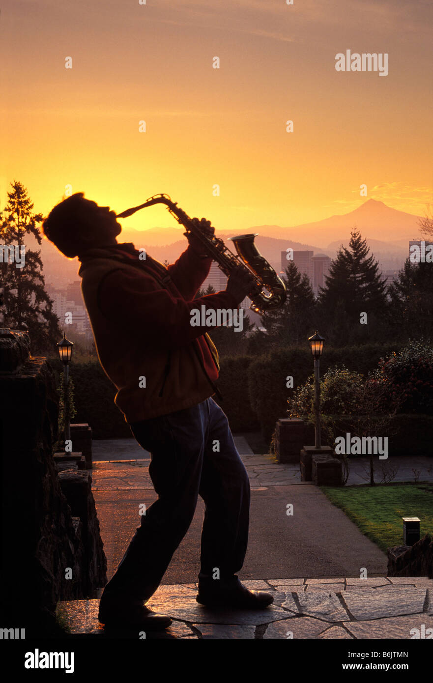 Saxaphone player, playing to a beautiful sunrise with Mt. Hood in the ...