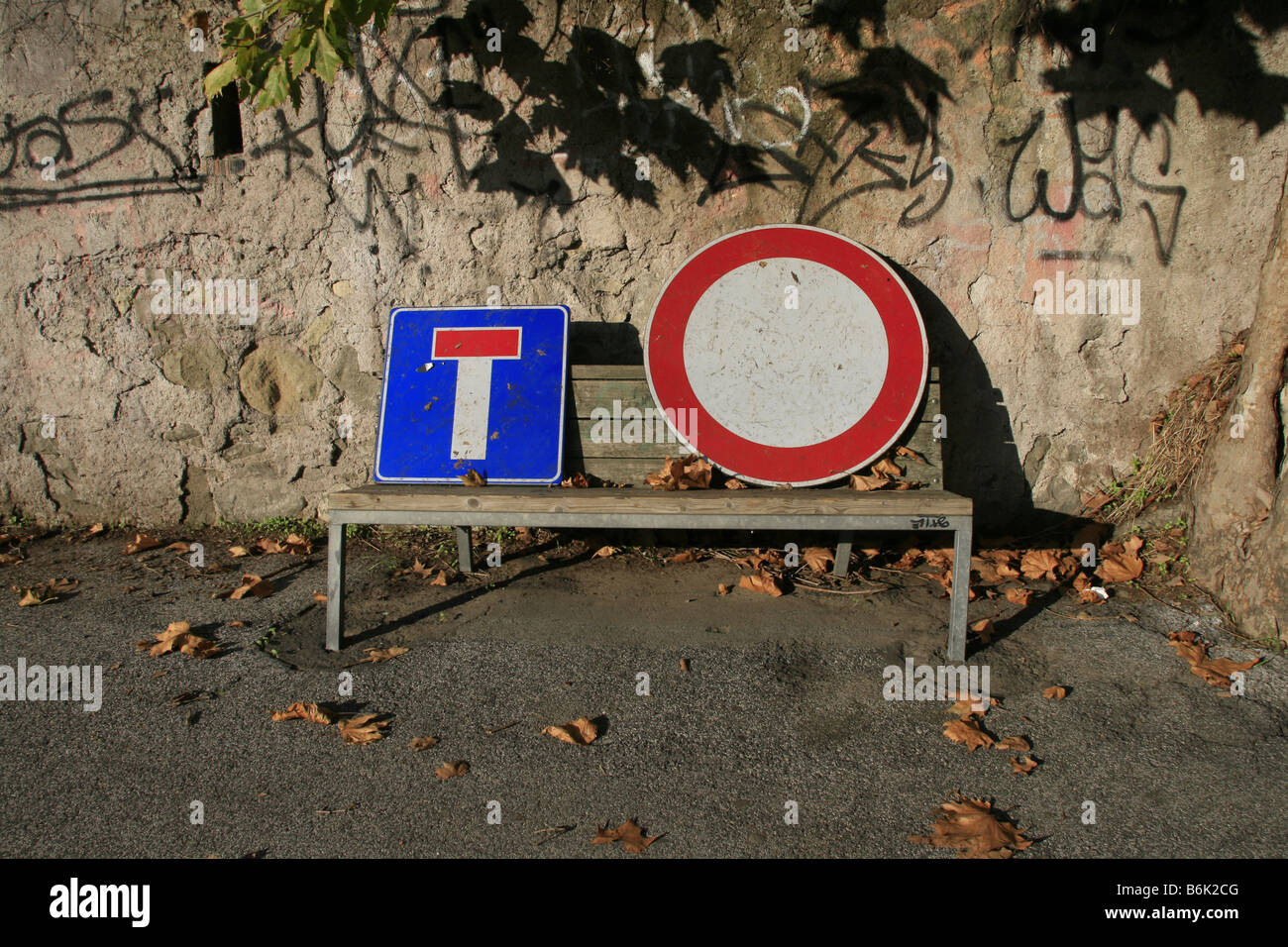 two damaged road traffic signs on bench in park Stock Photo - Alamy