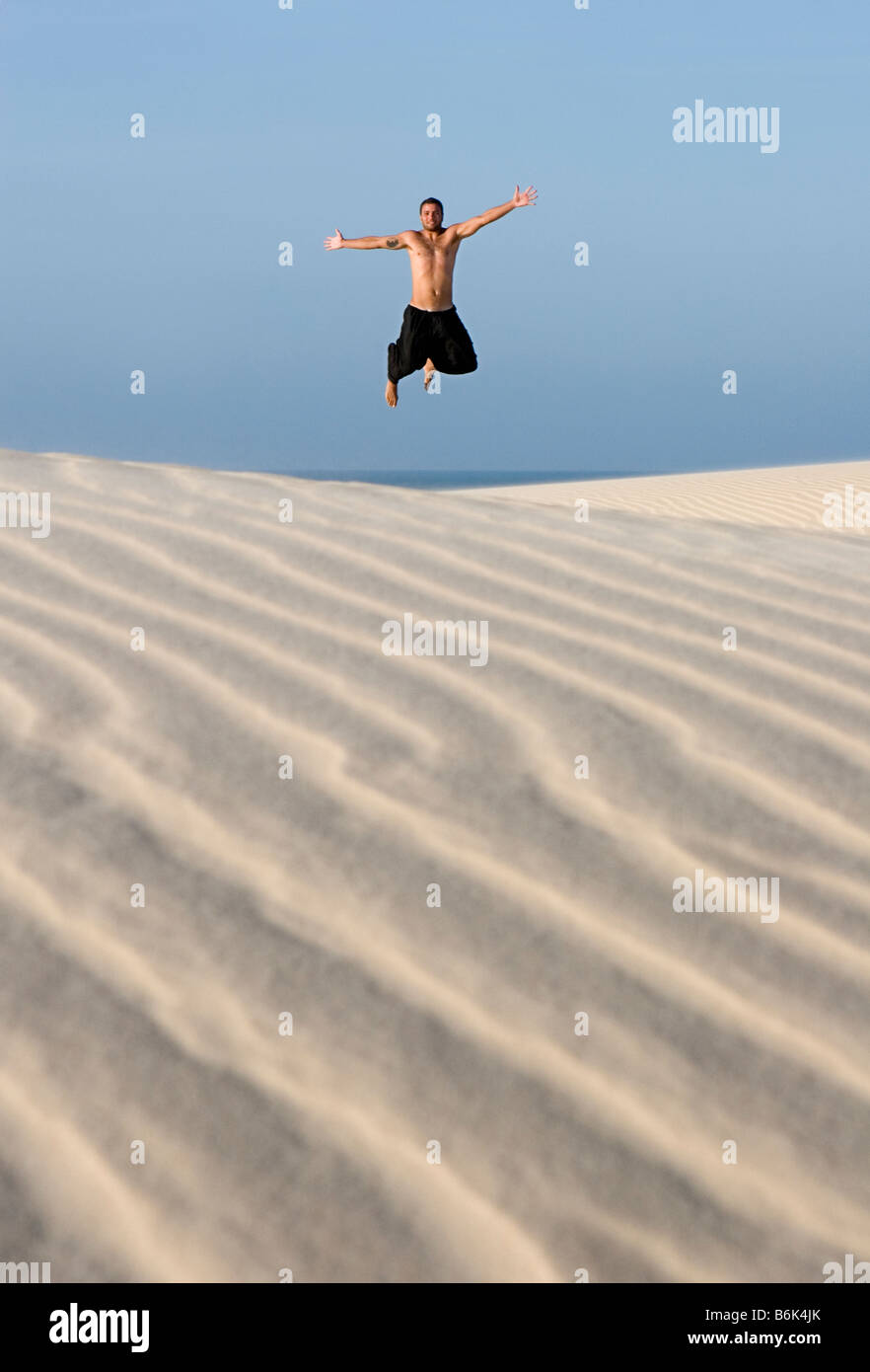 Man jumping above sand dune Stock Photo - Alamy