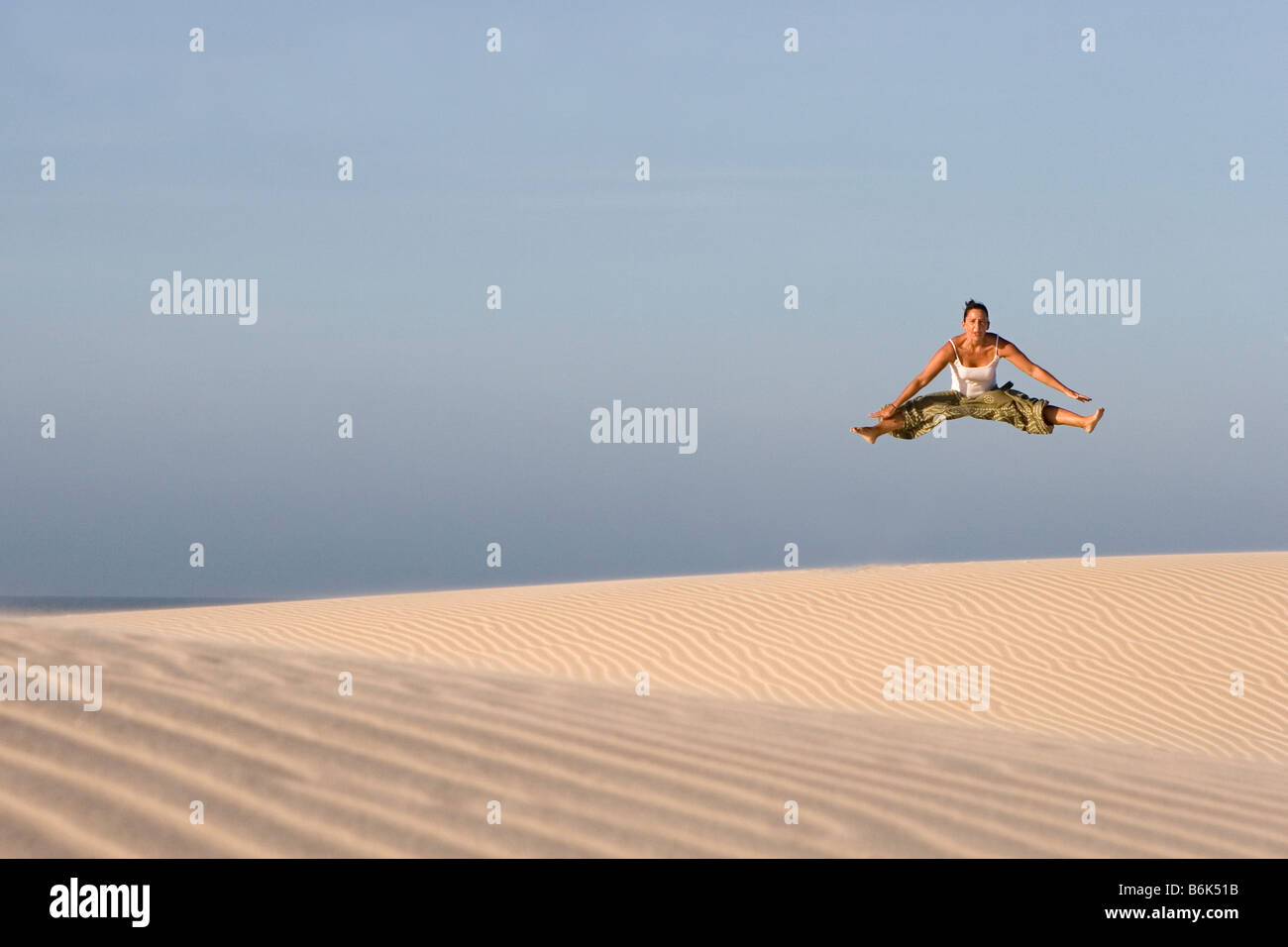woman jumping above sand dune Stock Photo - Alamy