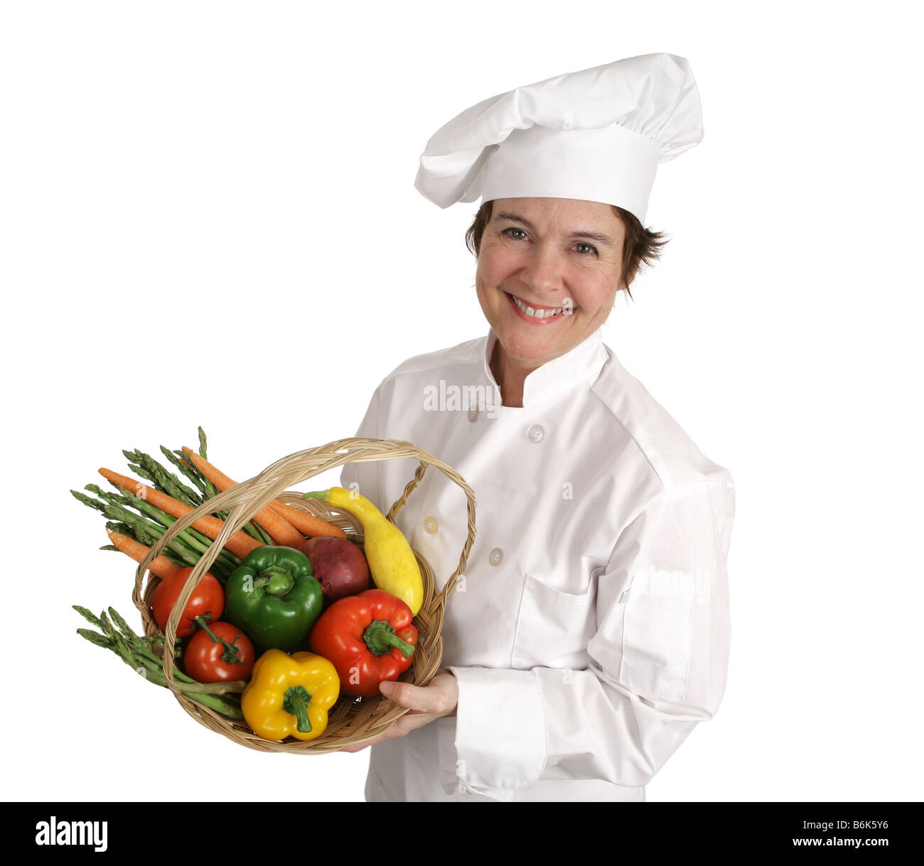An attractive female chef holding a basket of delicious fresh ...