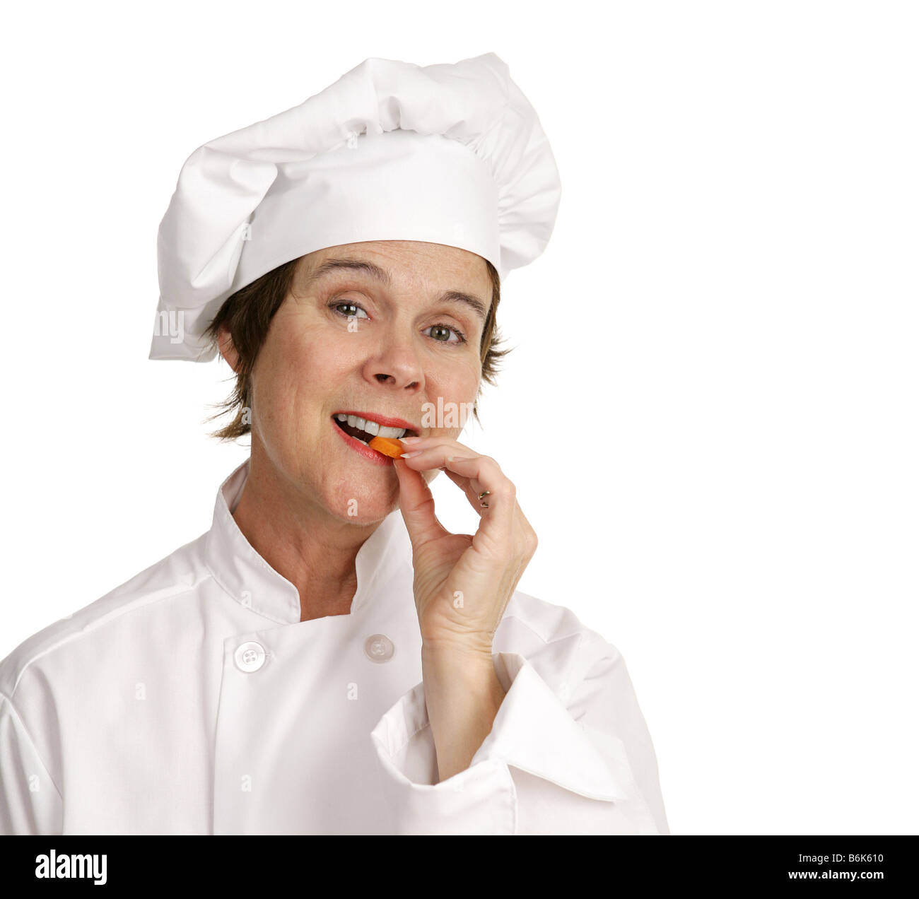 A pretty chef snacking on a healthy carrot Isolated on white with room ...