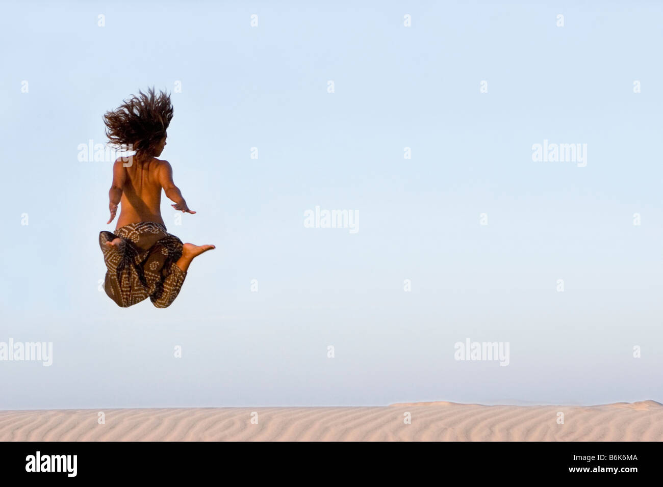 woman jumping above sand dune Stock Photo - Alamy