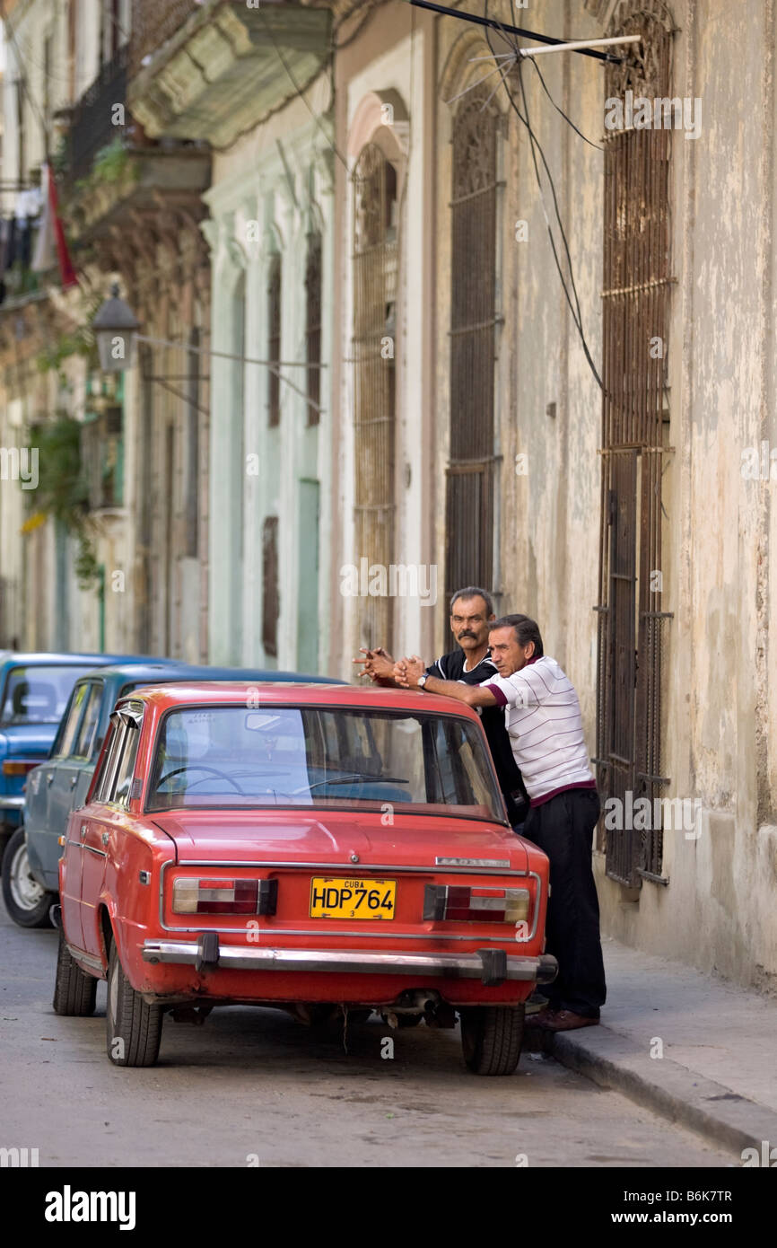 Two Cuban men standing close to the old Russian car Lada. Cuba, Havana ...