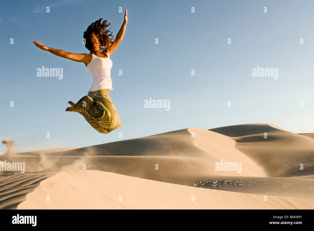 woman jumping above sand dune Stock Photo - Alamy
