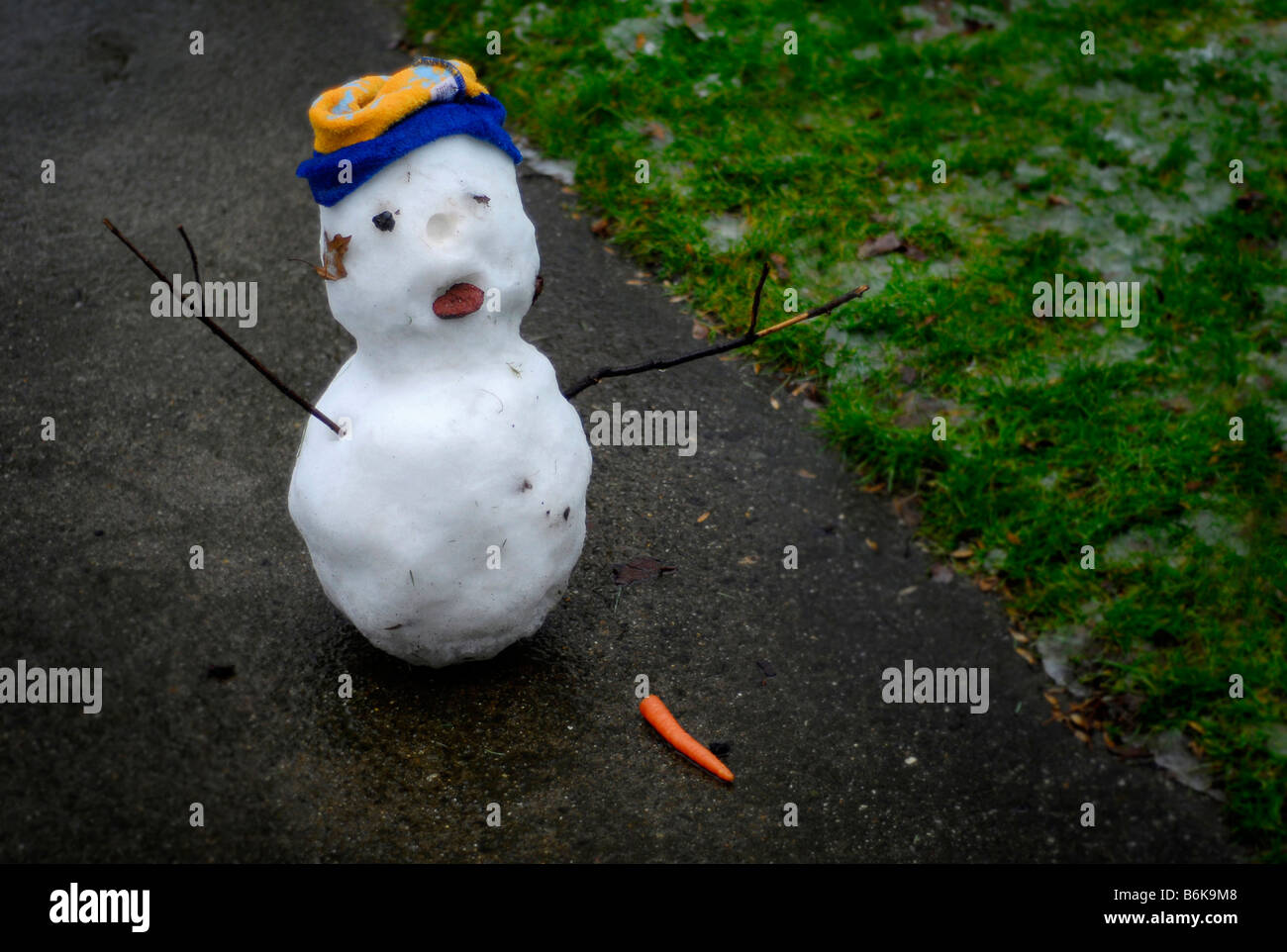 As a snowman melts, his nose falls to the ground Stock Photo - Alamy