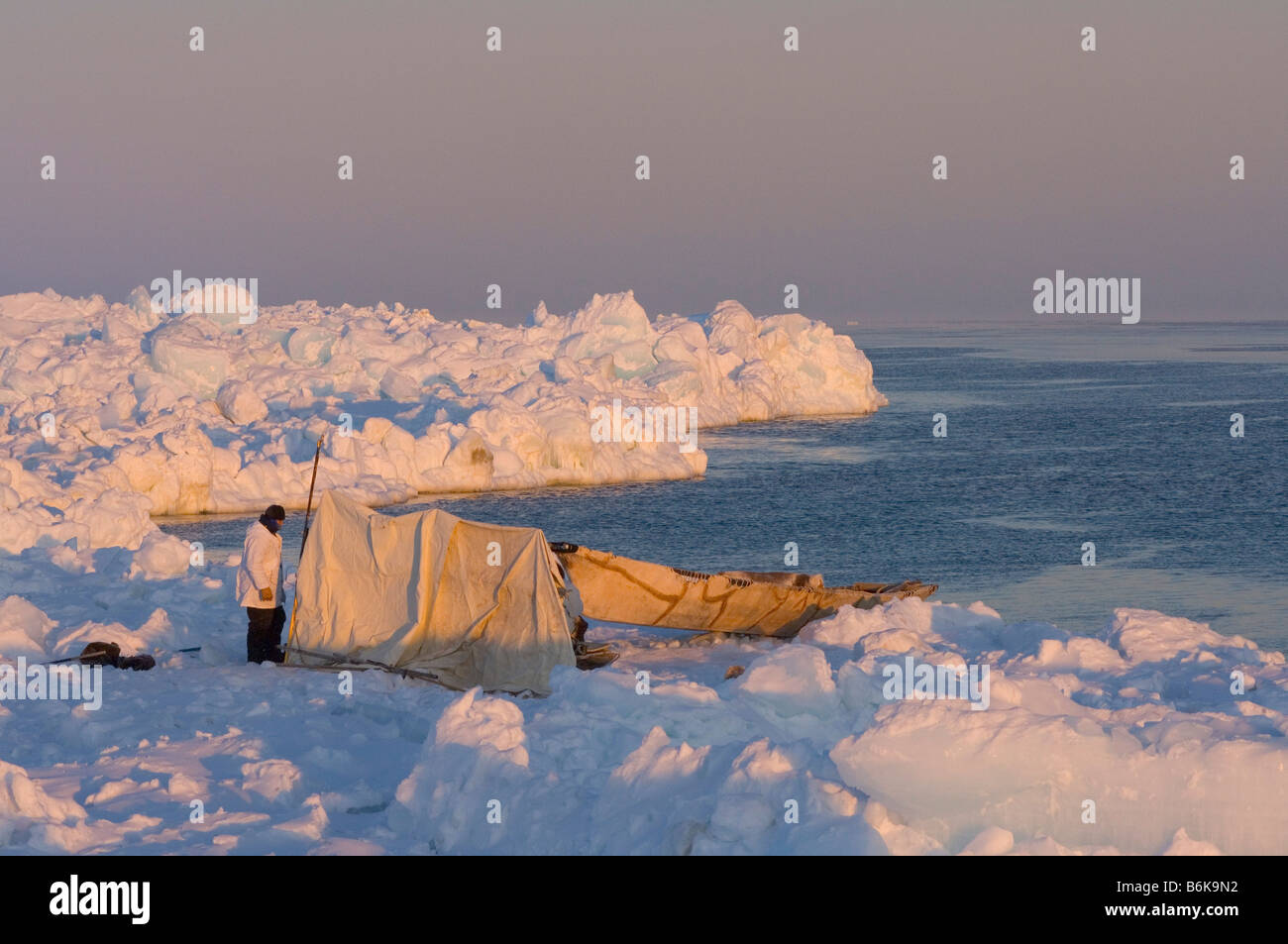 Inupiaq seal skin boat or umiak at the edge of an open lead in the pack ...
