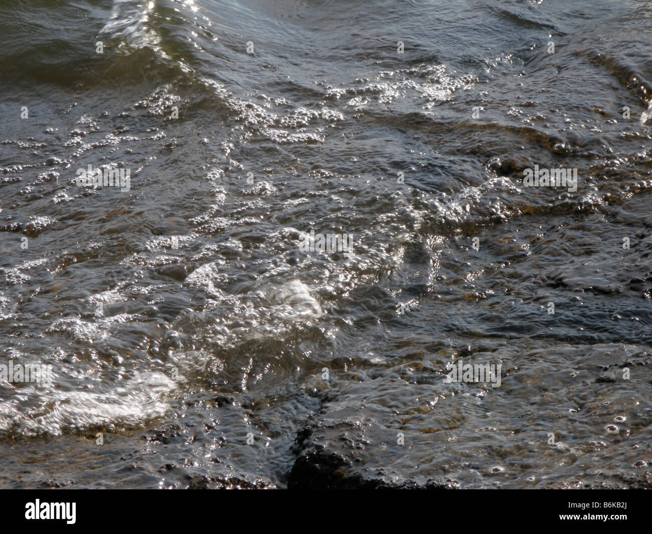 Water lapping over stones. Lake Victoria, Uganda Stock Photo - Alamy