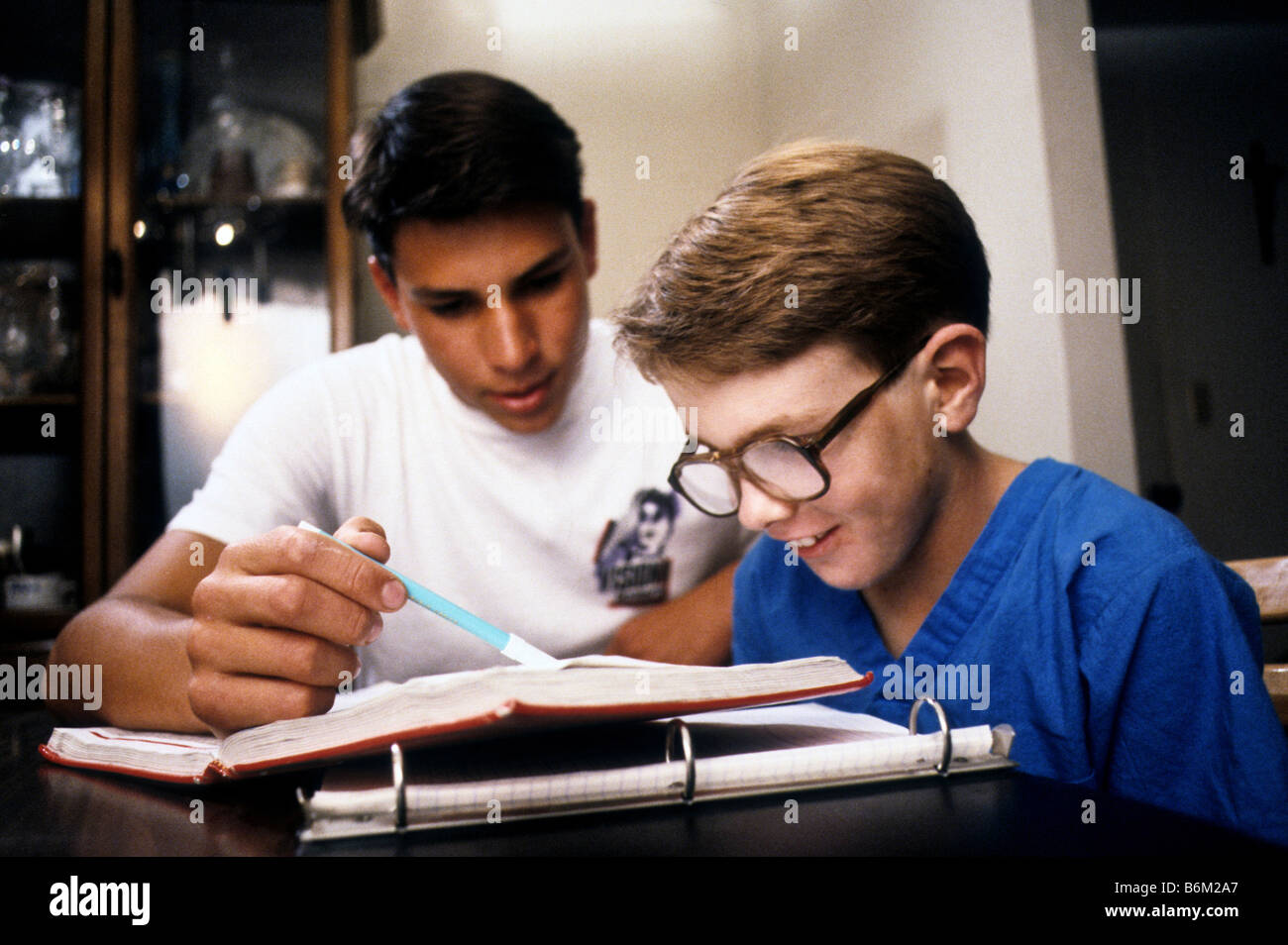 Teen boy helps younger brother with school homework Stock Photo - Alamy
