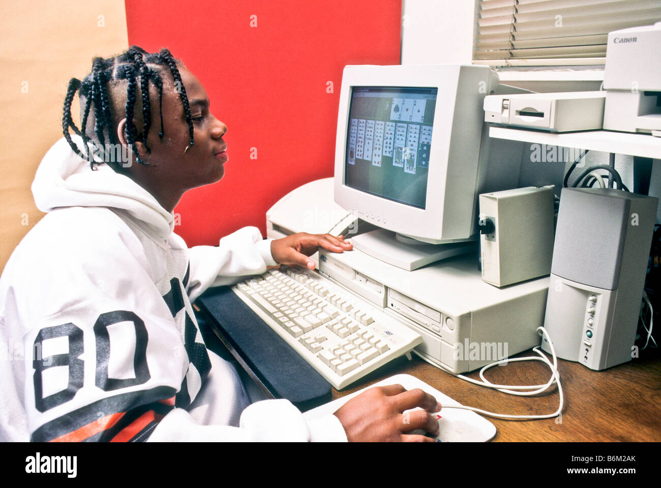 Black teen boy works on home computer Stock Photo - Alamy