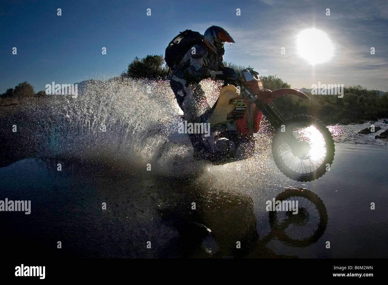 motorcycle rider splashing across stream in Central Nevada Stock Photo ...