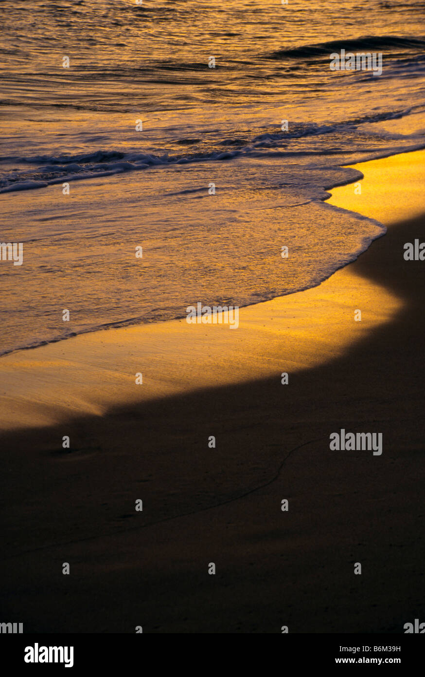 Ocean waves roll ashore at sunset at Polo beach, Maui, Hawaii, USA ...