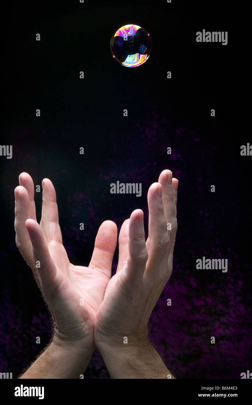 Two hands try to grasp a soap bubble floating in the air Stock Photo ...