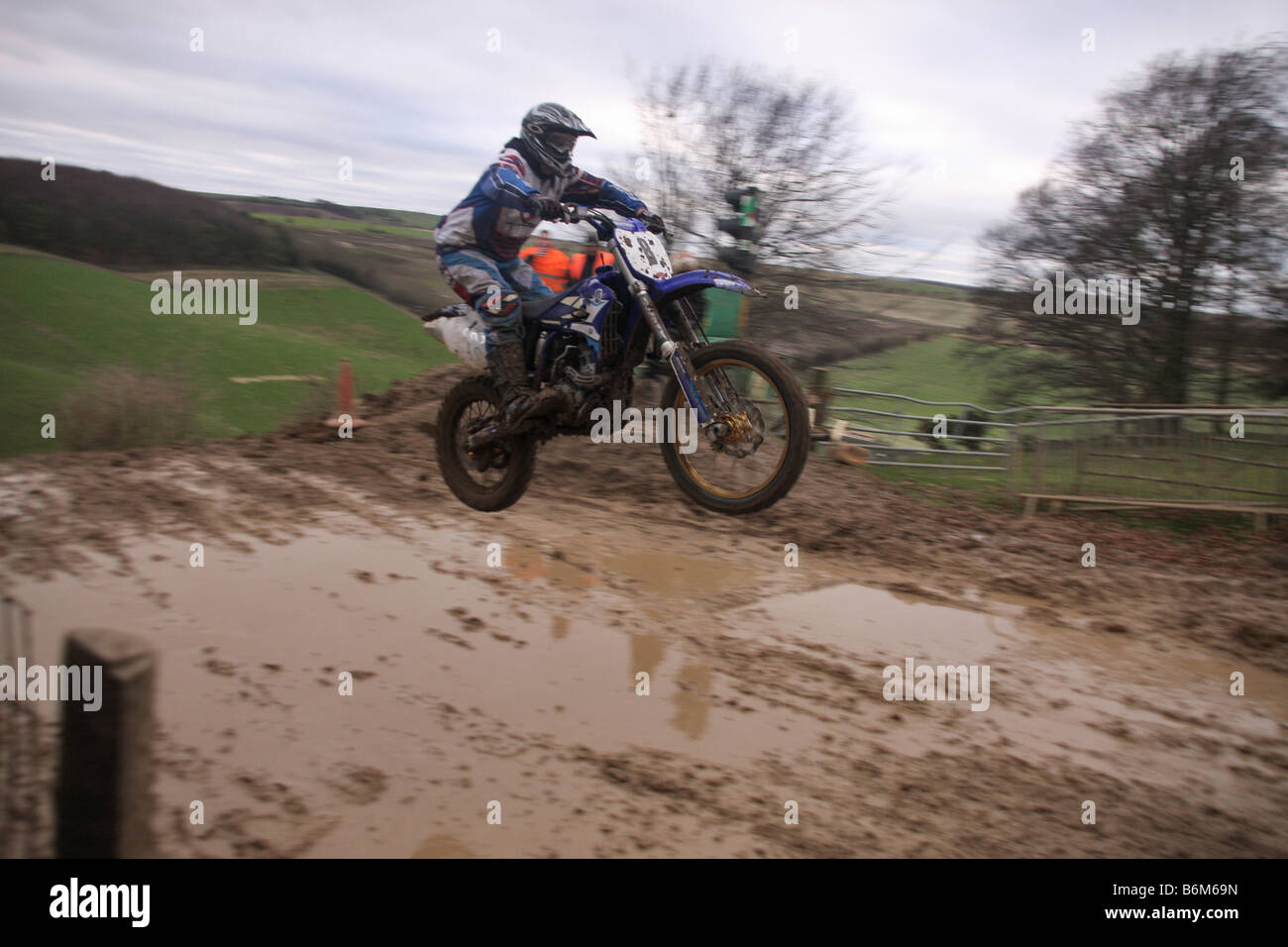 Motocross rider performing jump at dirt track Stock Photo - Alamy