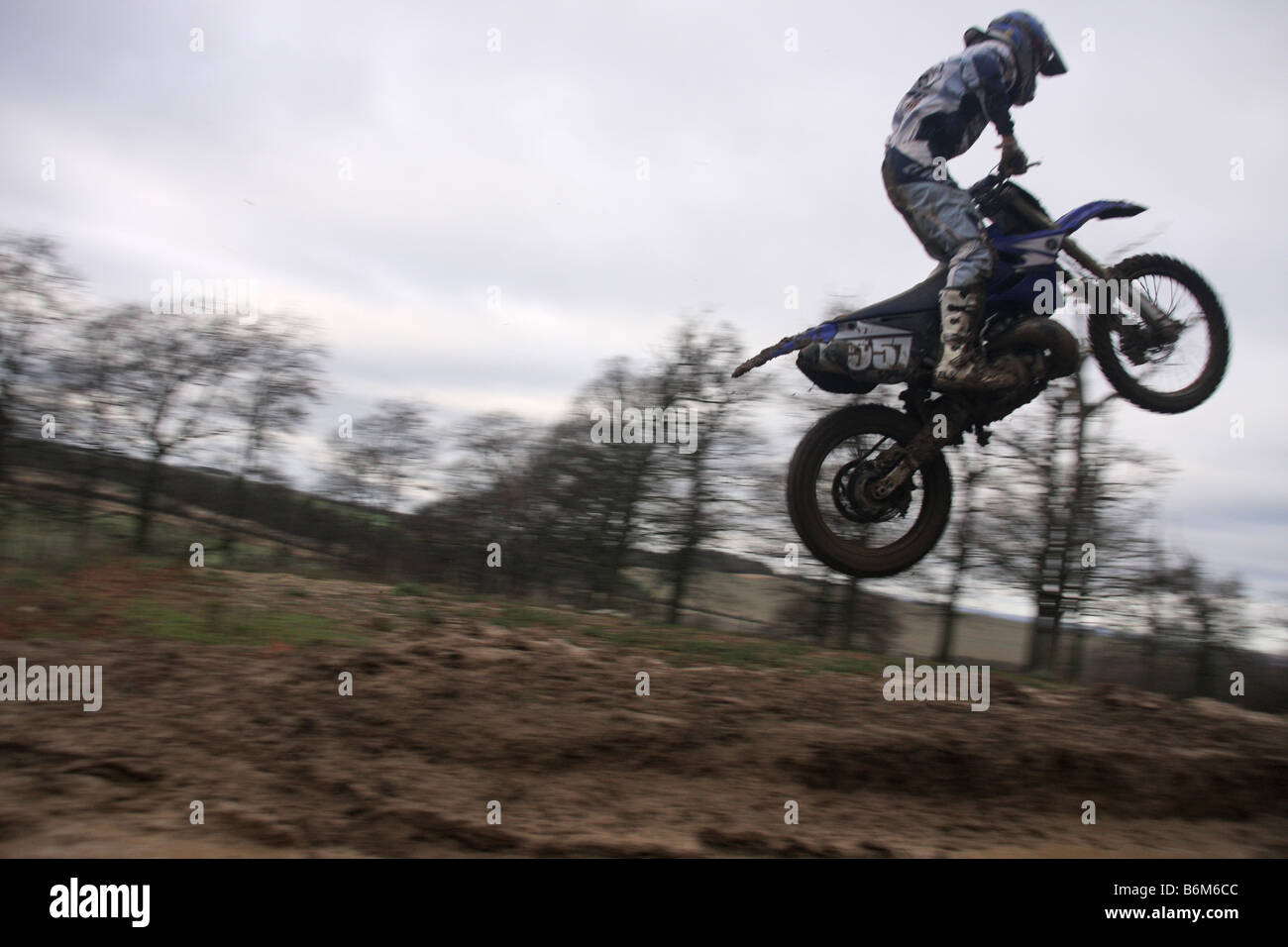Motocross rider performing jump at dirt track Stock Photo - Alamy