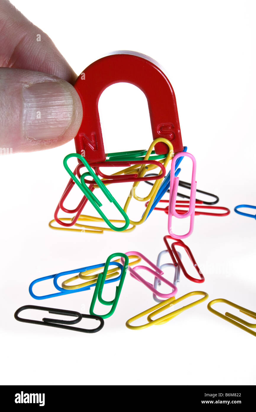 Brightly colored steel paperclips suspended from a horseshoe magnet ...