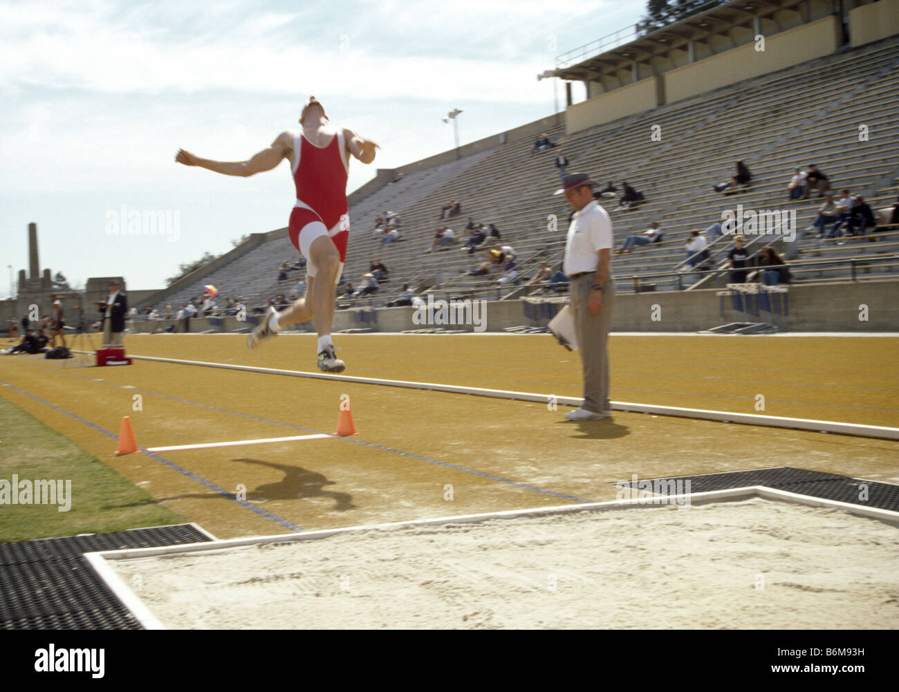 A male athlete leaps through the air to land the long-jump Stock Photo ...
