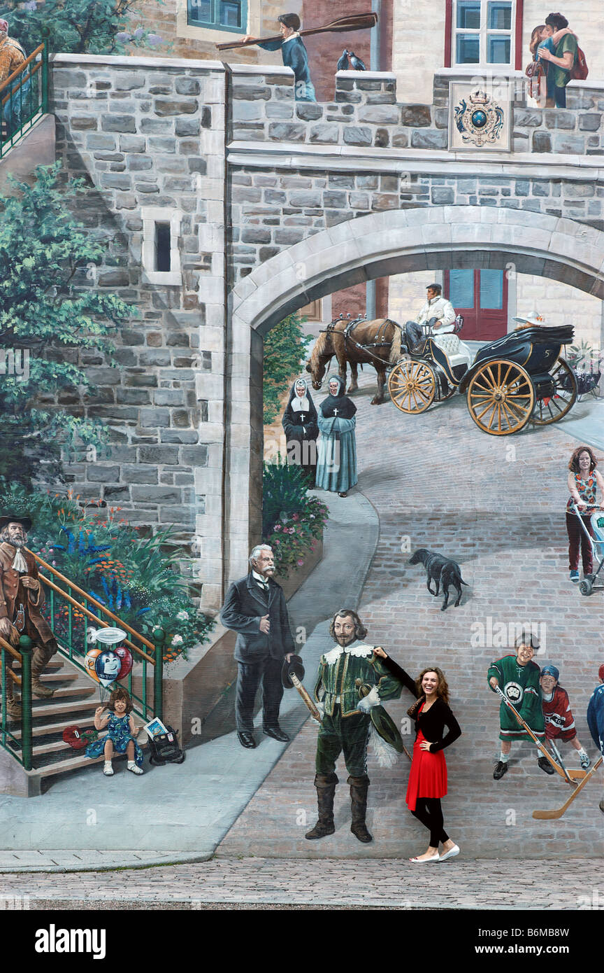 A woman posing for her picture by a figure painted on a wall mural in ...