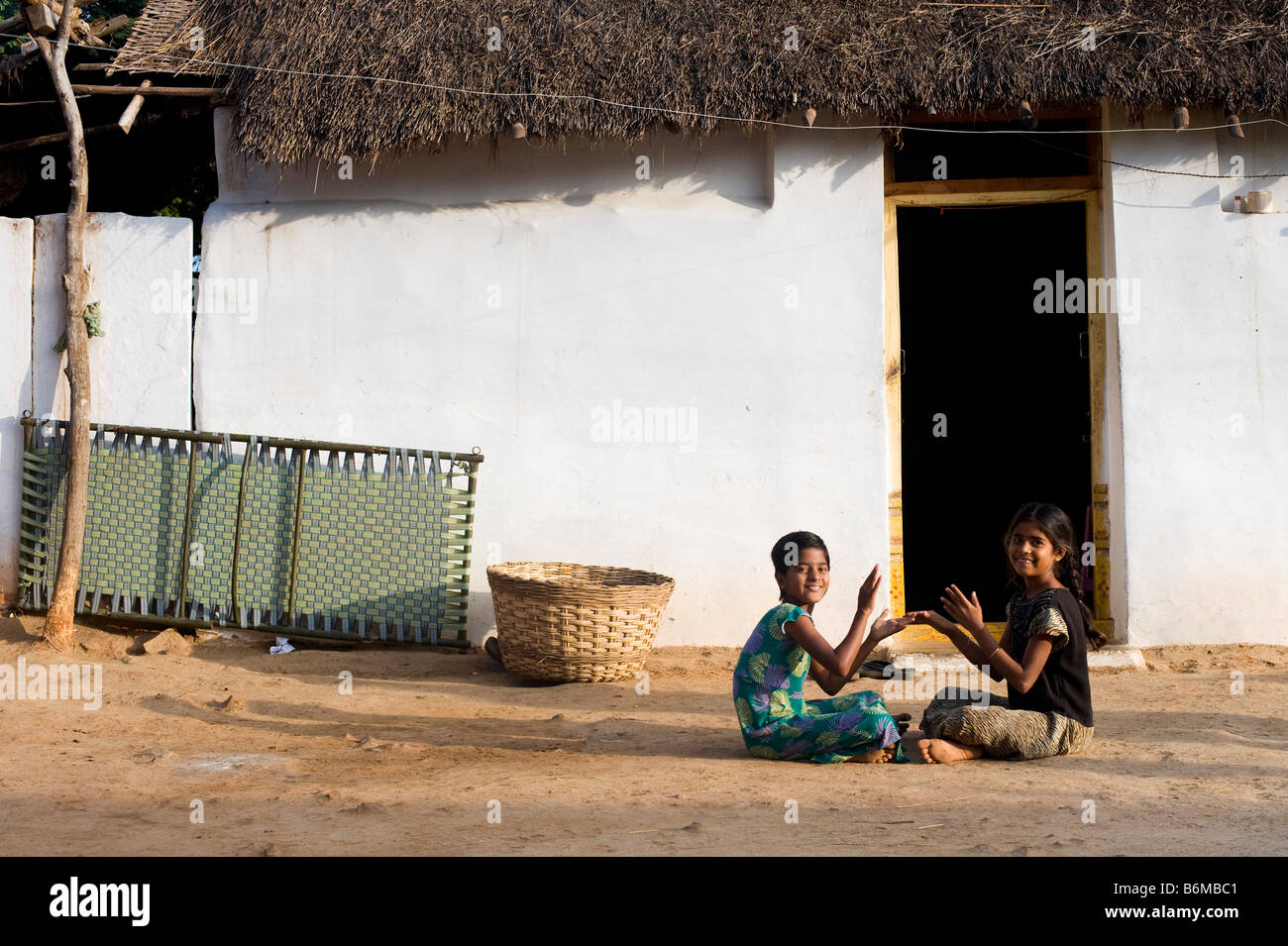 Young Indian village girls playing a hand clapping game outside a rural ...