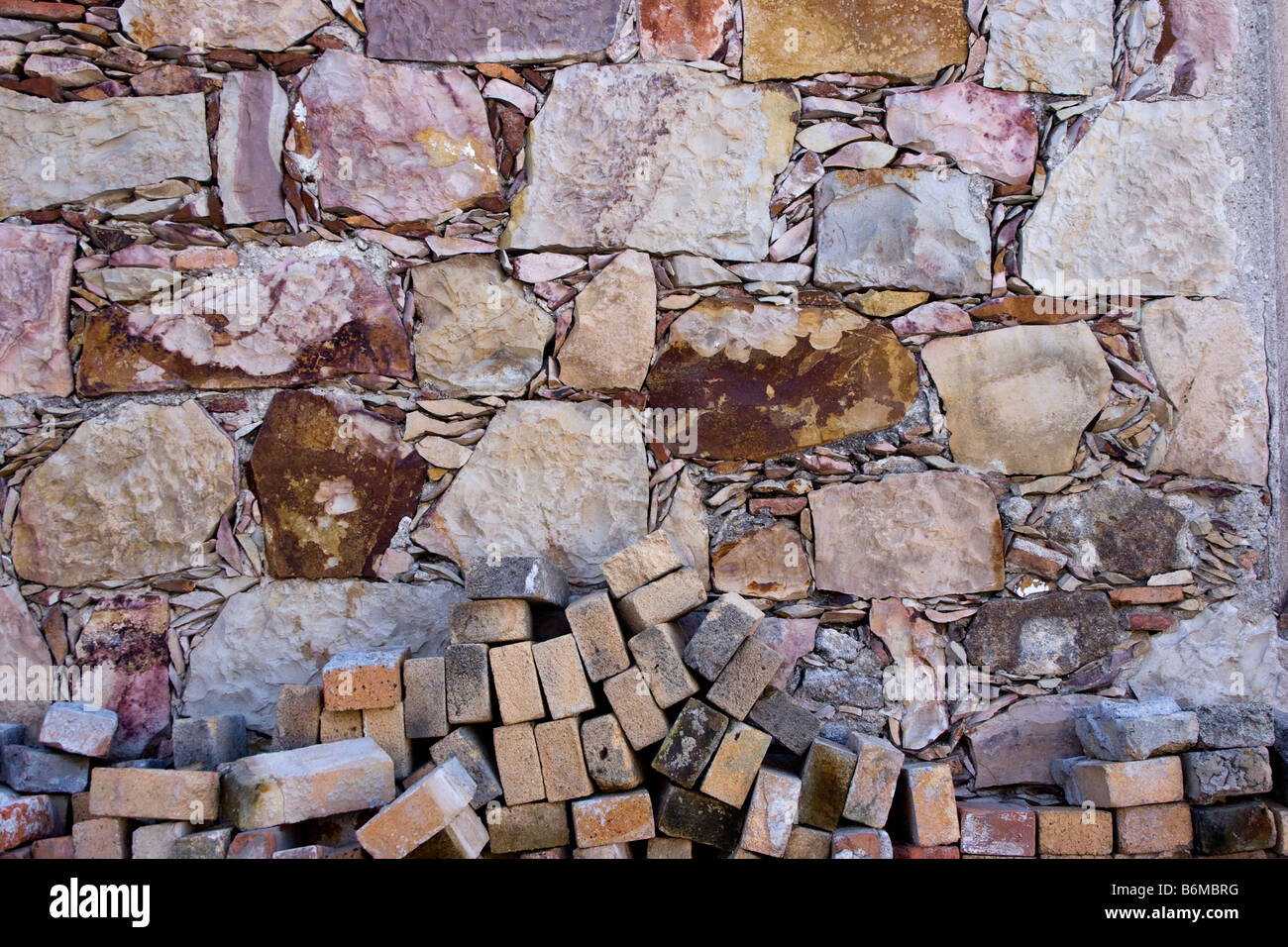 Stack of bricks against a stone wall in San Miguel de Allende Mexico ...