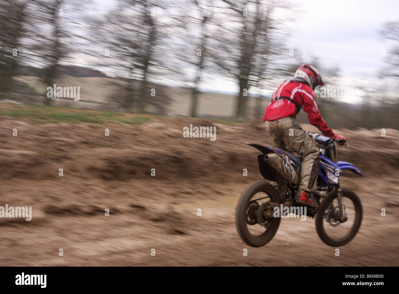 Motocross rider performing jump at dirt track Stock Photo - Alamy