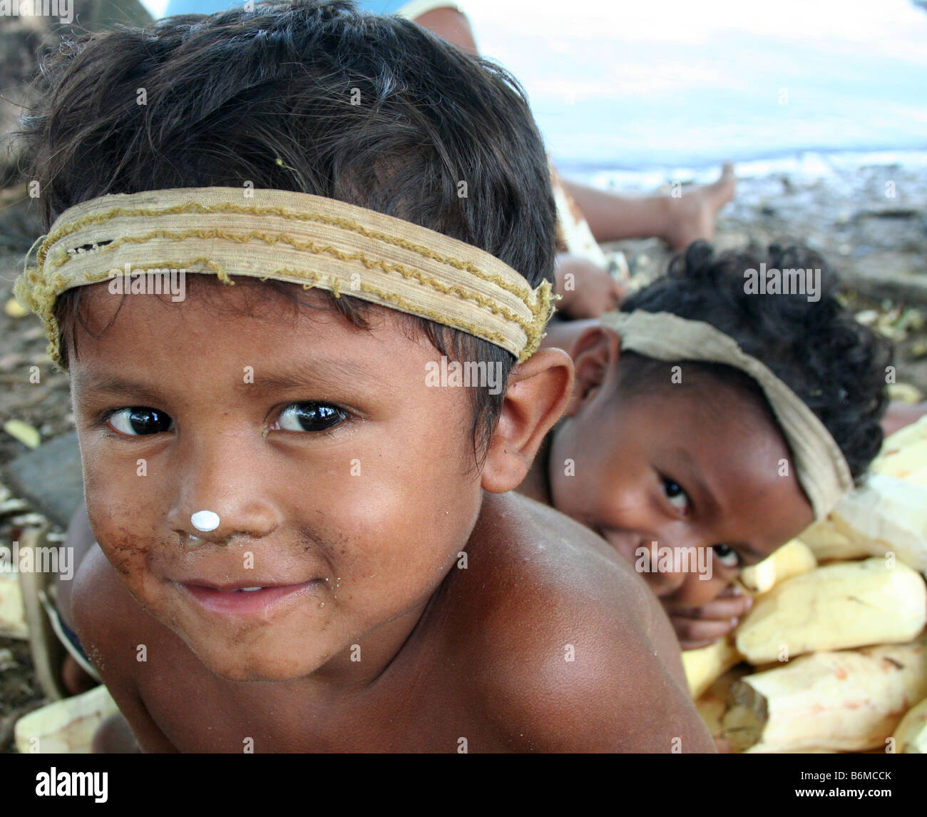 Two rural Amazonian Brazilian boys play mischievously by a river, next ...