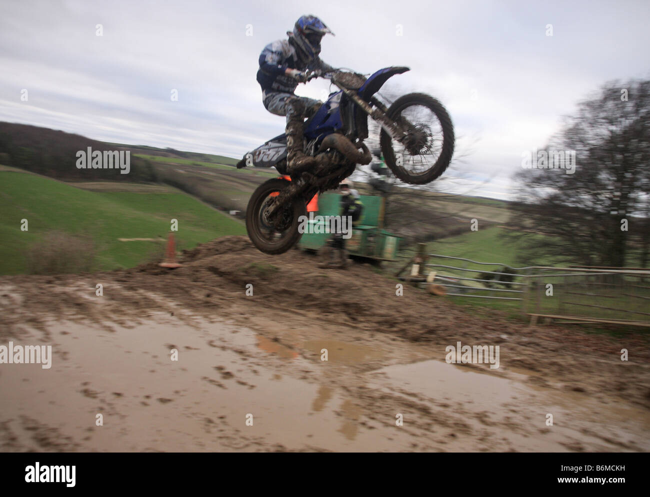 Motocross rider performing jump at dirt track Stock Photo - Alamy