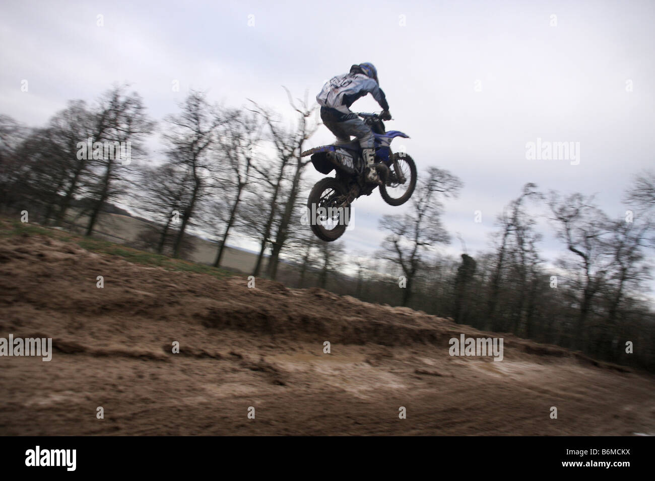 Motocross rider performing jump at dirt track Stock Photo - Alamy