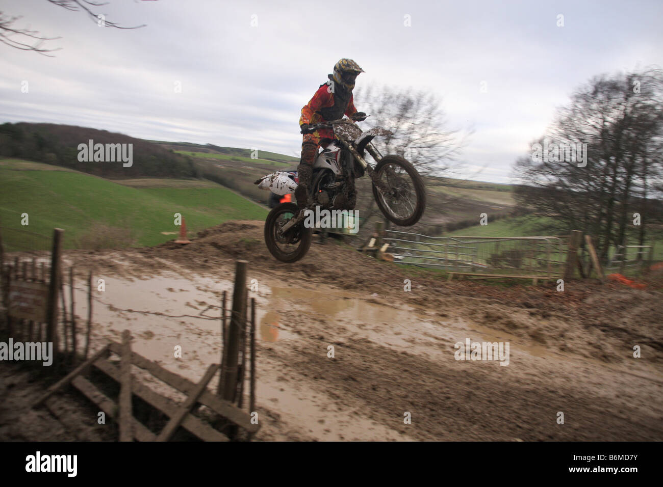 Motocross rider performing jump at dirt track Stock Photo - Alamy