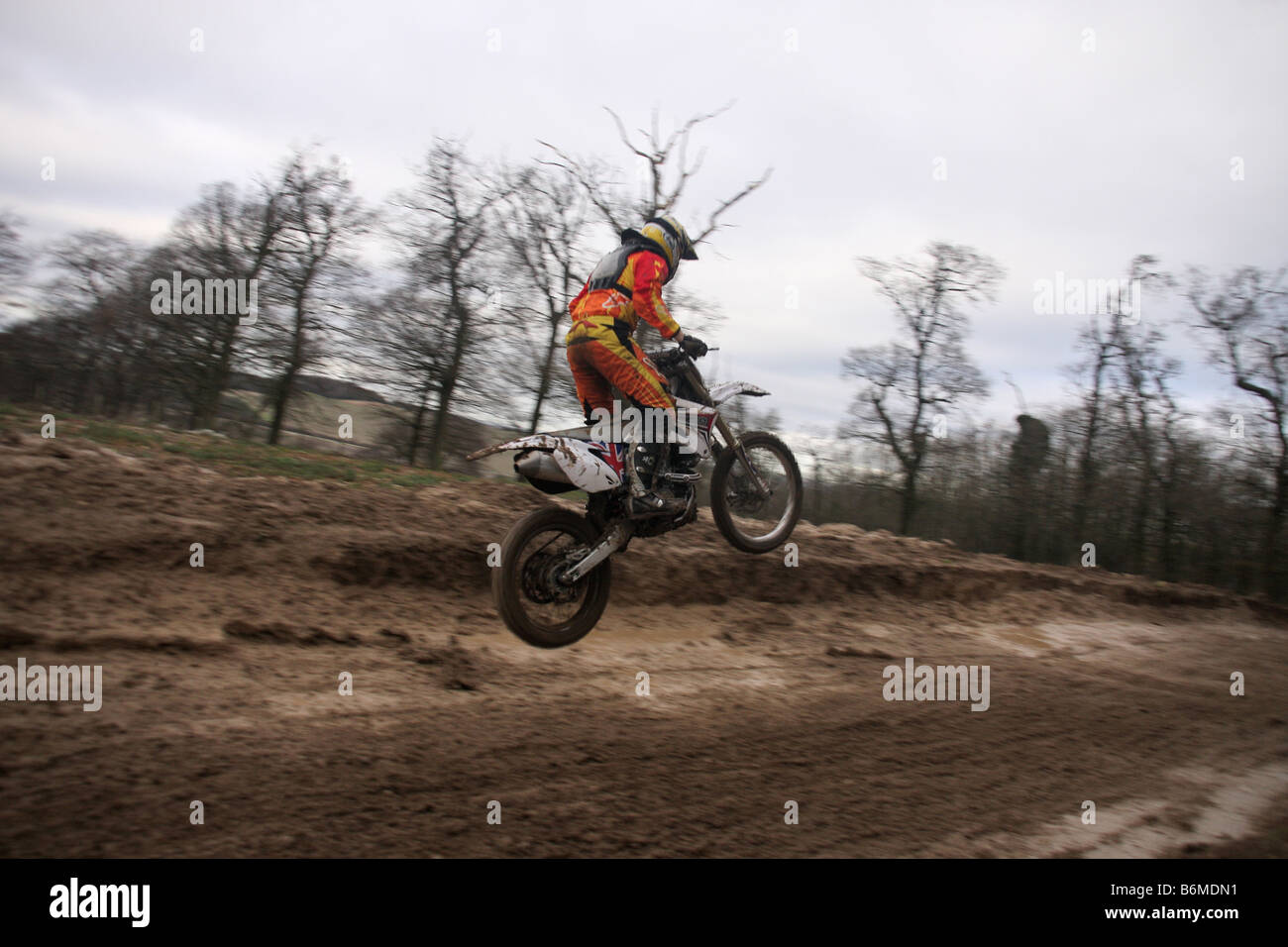 Motocross rider performing jump at dirt track Stock Photo - Alamy