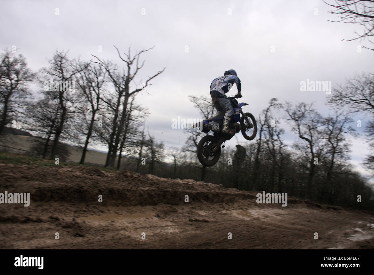 Motocross rider performing jump at dirt track Stock Photo - Alamy