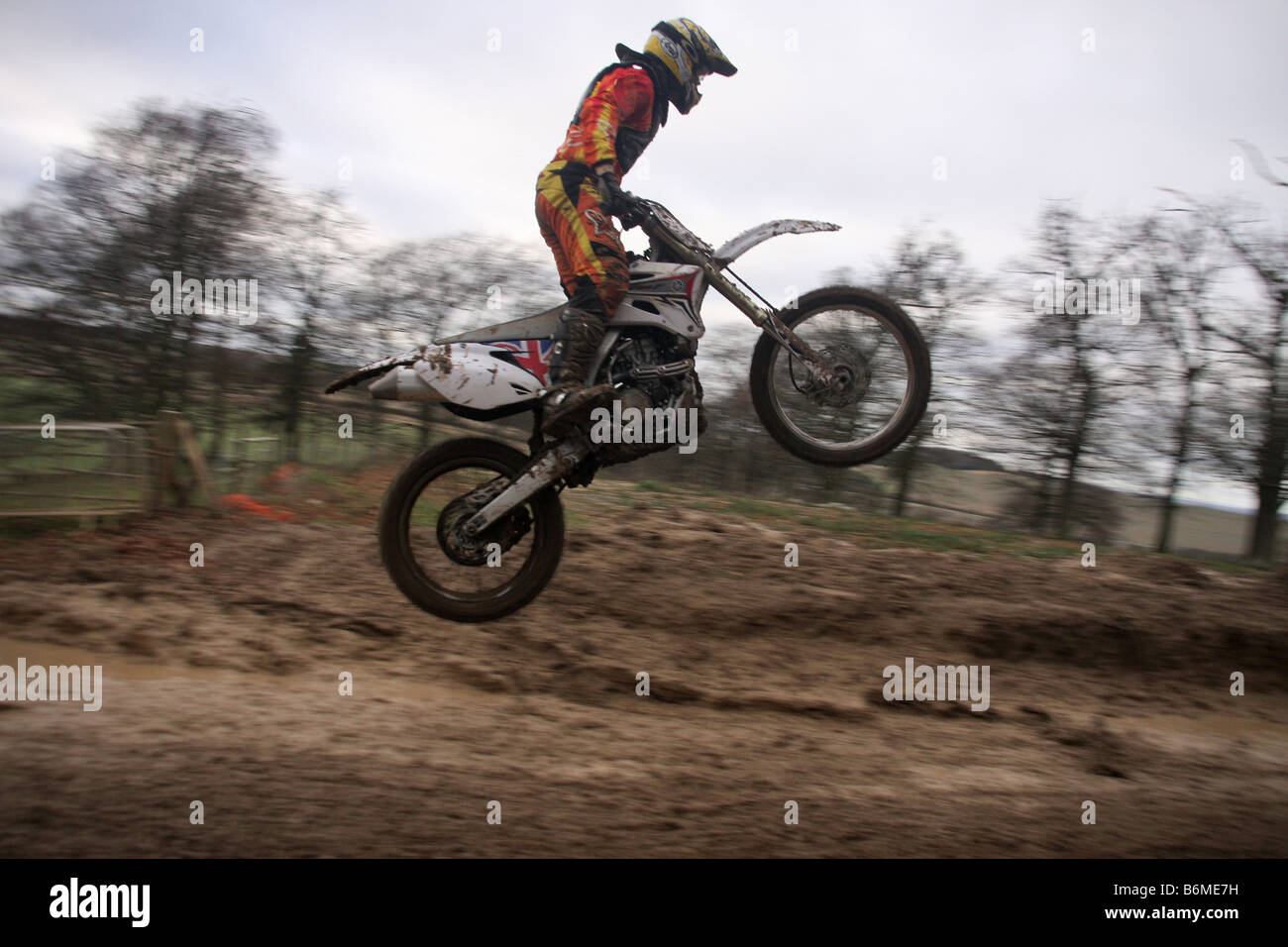 Motocross rider performing jump at dirt track Stock Photo - Alamy