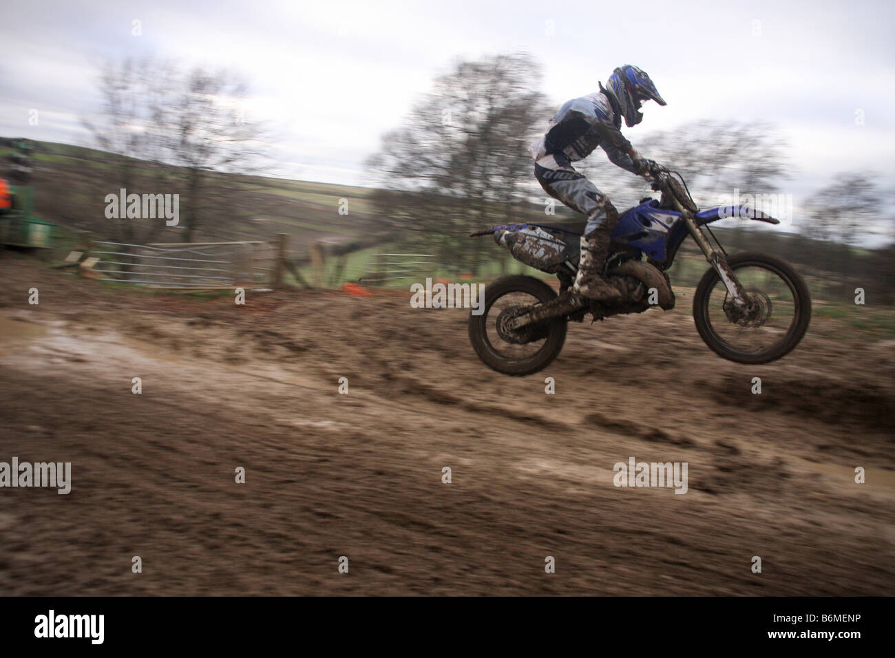 Motocross rider performing jump at dirt track Stock Photo - Alamy