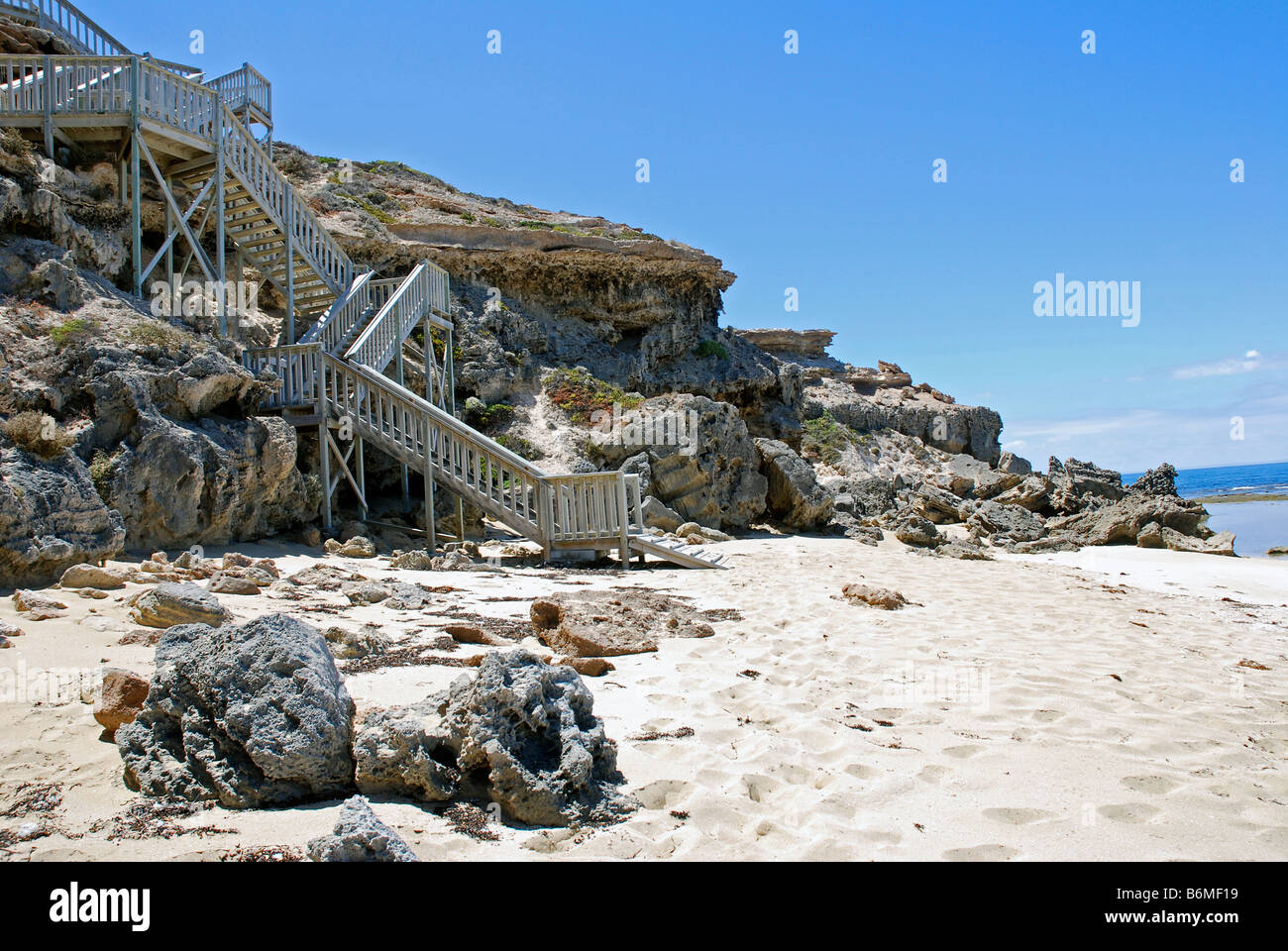 Stairs leading down the cliffs onto the beach with tidal pool Stock ...
