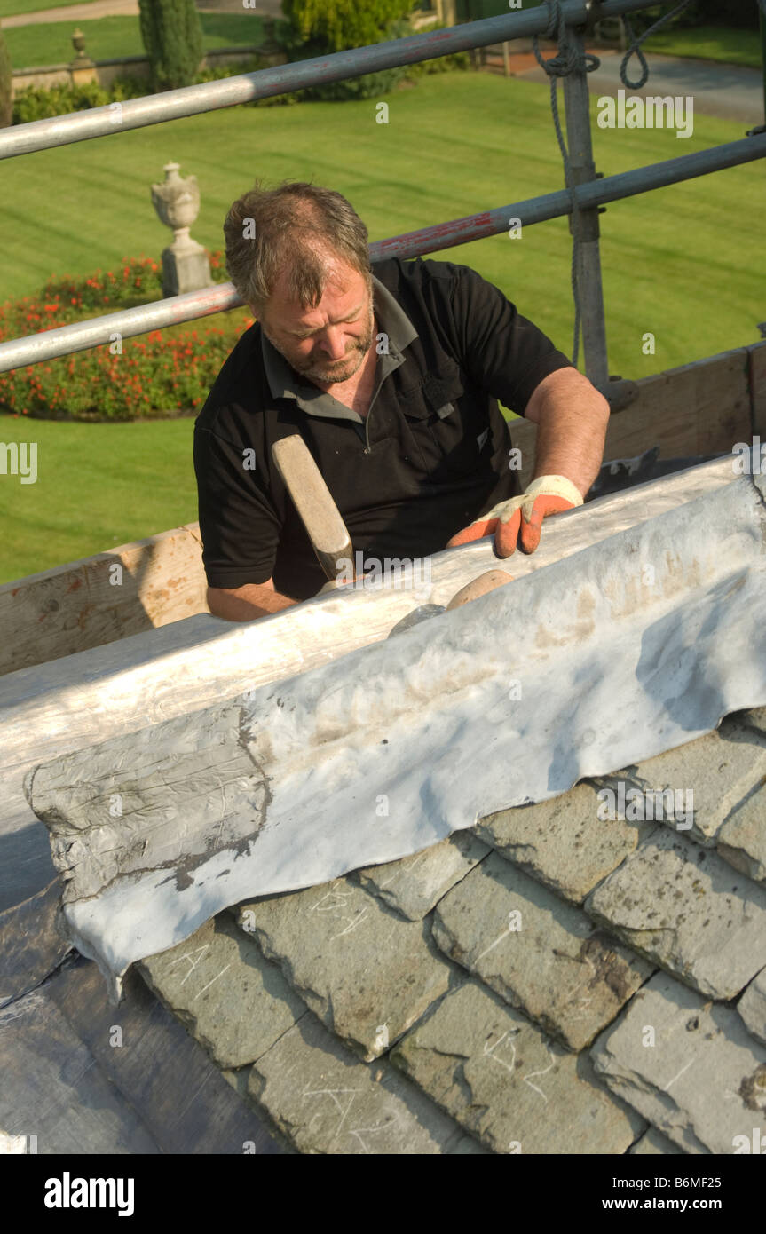 Planishing lead on a traditional slate roof to affect a repair Stock ...