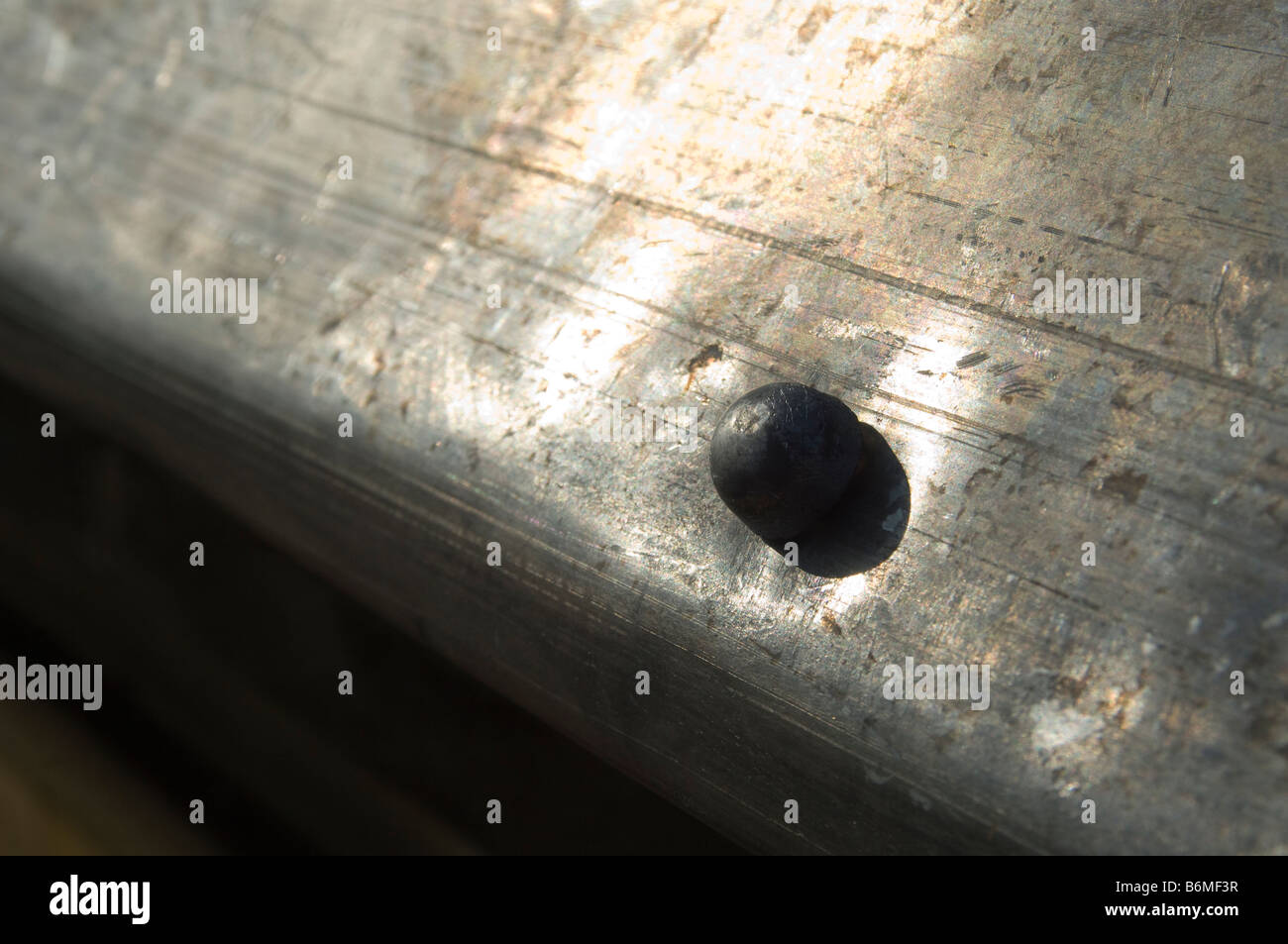 Close up of rivet securing renewed lead sheeting on traditional roof ...