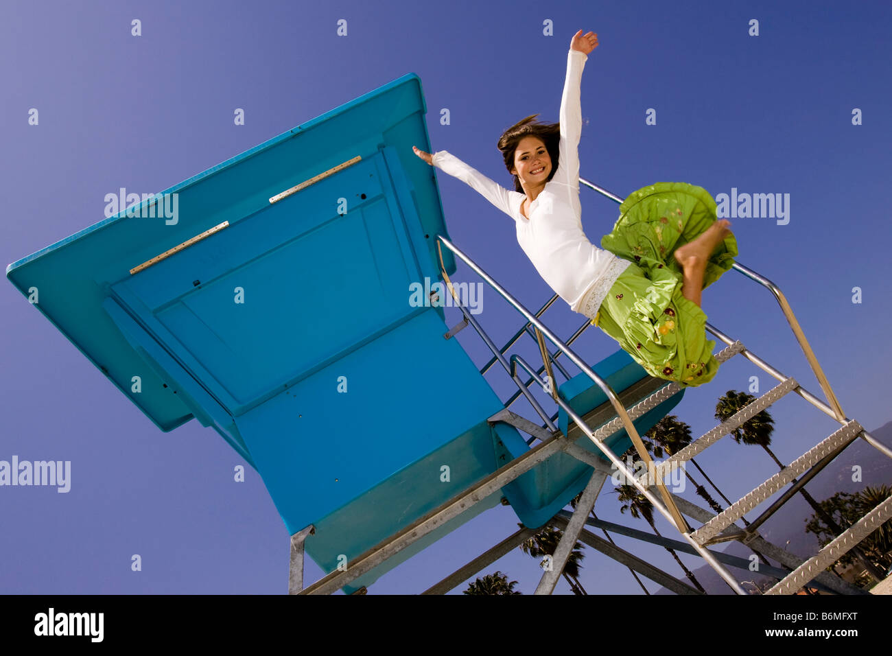 Caucasian female teen jumping from lifeguard stand - California USA ...